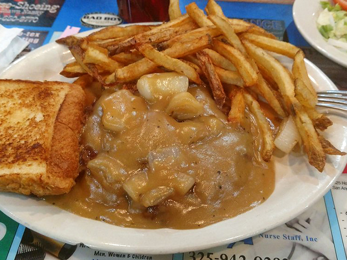 Hamburger steak swimming in gravy so rich it could probably solve world hunger one bite at a time.