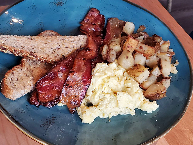 Breakfast that understands the fundamental truth: perfectly cooked eggs, crispy bacon, and golden potatoes are the holy trinity of morning happiness.