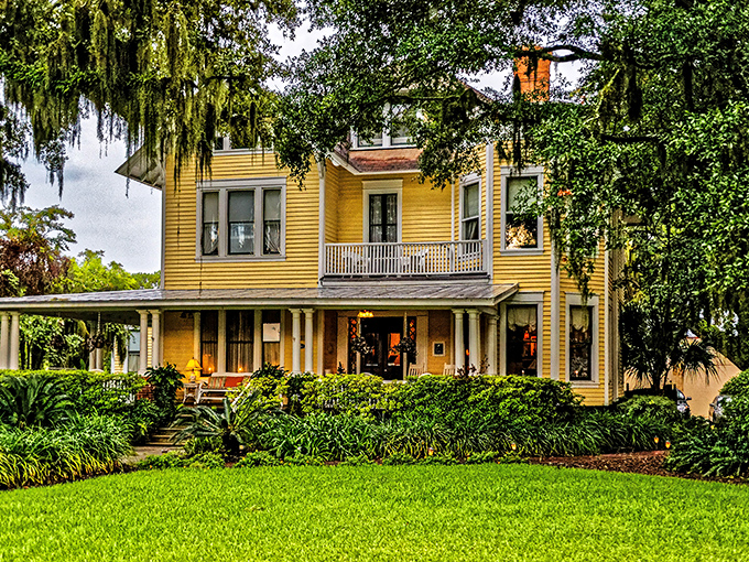 Sunshine yellow Victorian charm wrapped in Spanish moss and tropical foliage&mdash;the kind of porch that practically demands a good book and glass of sweet tea.