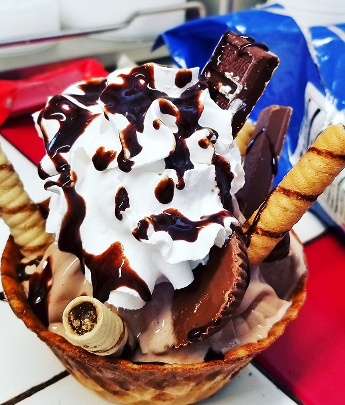 Ice cream architecture at its finest&mdash;where whipped cream, chocolate sauce, and wafer straws create a skyline worth demolishing.