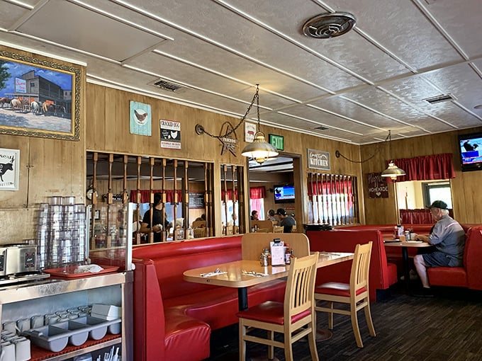 Red booths and wood paneling create that classic diner atmosphere where you half-expect to see your parents' younger selves enjoying breakfast in 1975.