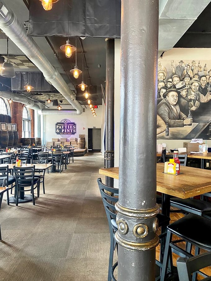 The spacious interior features industrial columns, vintage-inspired lighting, and a mural that tells stories of gatherings past &ndash; a modern speakeasy for food enthusiasts.