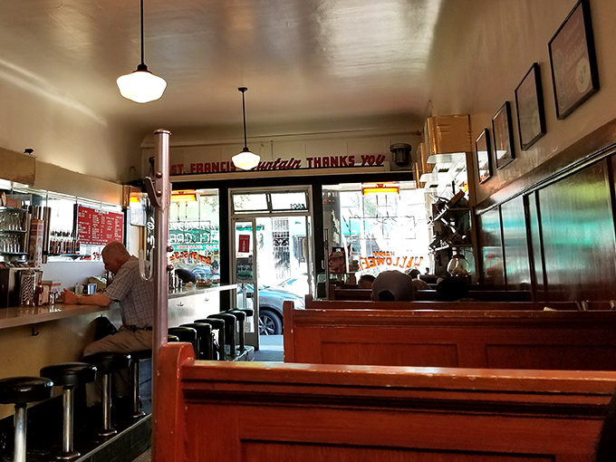 The warm wooden booths and counter seating create that perfect diner atmosphere where strangers become temporary neighbors united by good food.