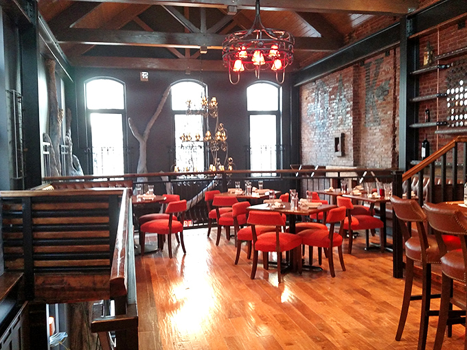 Red chairs pop against rustic wood and brick in this upstairs dining area&mdash;like sitting in a modern treehouse built for grown-ups who love steak.