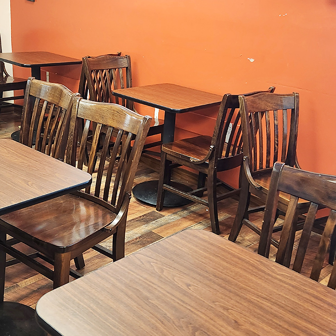 The dining area's warm orange walls and well-worn wooden chairs invite you to sit awhile and savor every bite.