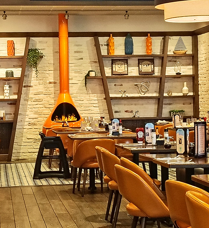 That striking orange fireplace isn't just decor&mdash;it's the soul of the room, surrounded by shelves that tell stories of design and comfort.