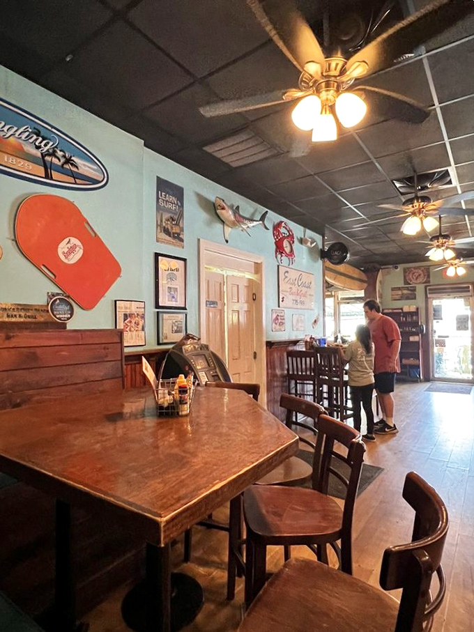 Turquoise walls adorned with coastal memorabilia create the perfect backdrop for seafood indulgence and vacation storytelling.