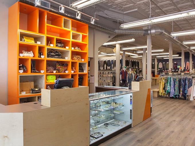 The bright orange shelving unit serves as both functional storage and eye-catching decor, drawing shoppers toward the jewelry case where tiny treasures await.