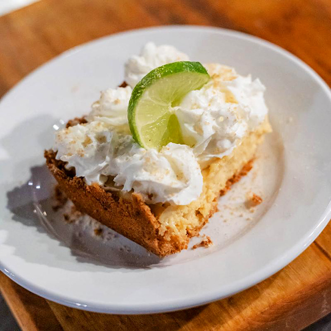 Key lime pie with a crown of whipped cream – the sweet, tart finale that somehow finds room in your steak-filled stomach.