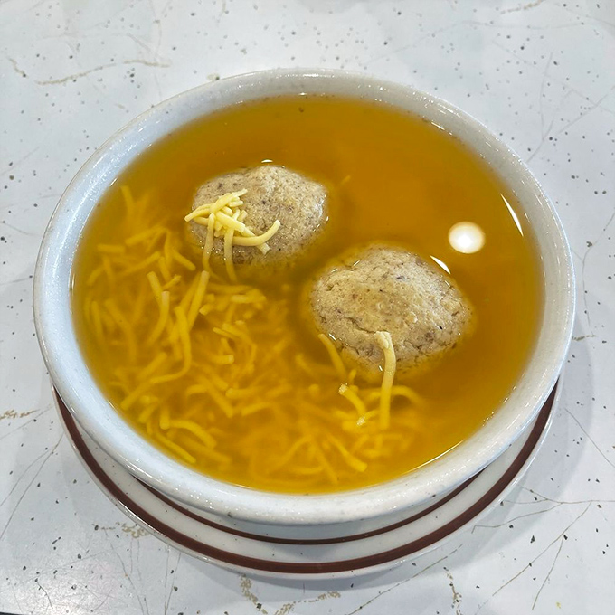 Two matzo balls floating in golden broth like planets in a delicious universe. Grandmothers everywhere nod in approval.