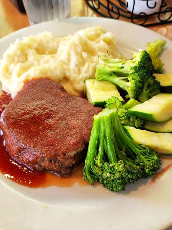 A meatloaf that would make your grandmother simultaneously proud and jealous, nestled beside mashed potatoes that clearly never came from a box.