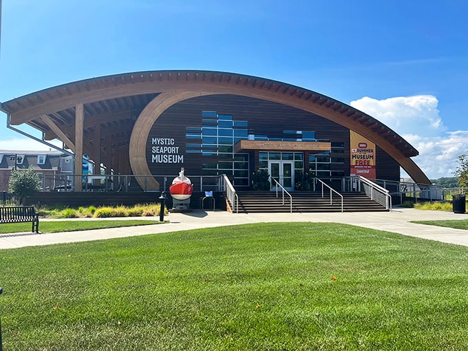 Mystic Seaport Museum's modern entrance curves like a wave, inviting visitors to dive into maritime history without getting their feet wet.