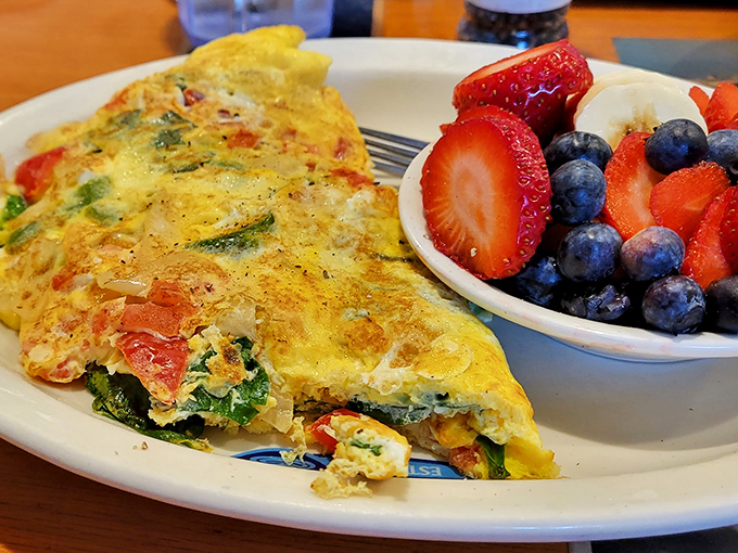 This omelet has more colorful ingredients than a Pixar movie, with a side of berries that look like they were picked moments ago.