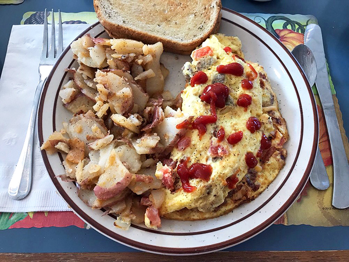 An omelet that doesn't just sit on the plate—it commands attention. Those home fries are the unsung heroes of breakfast plates everywhere.
