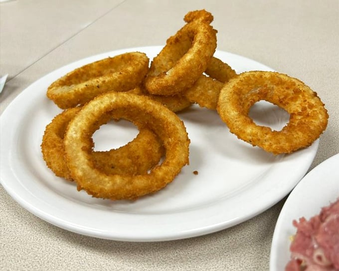 Golden, crispy onion rings that shatter with each bite. These aren't just sides&mdash;they're the supporting actors that deserve their own Oscar. 