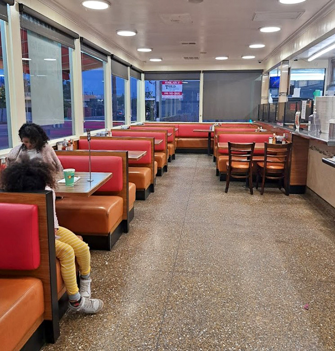 Classic diner seating where strangers become friends over coffee refills. The terrazzo floors have supported decades of hungry feet seeking comfort food.