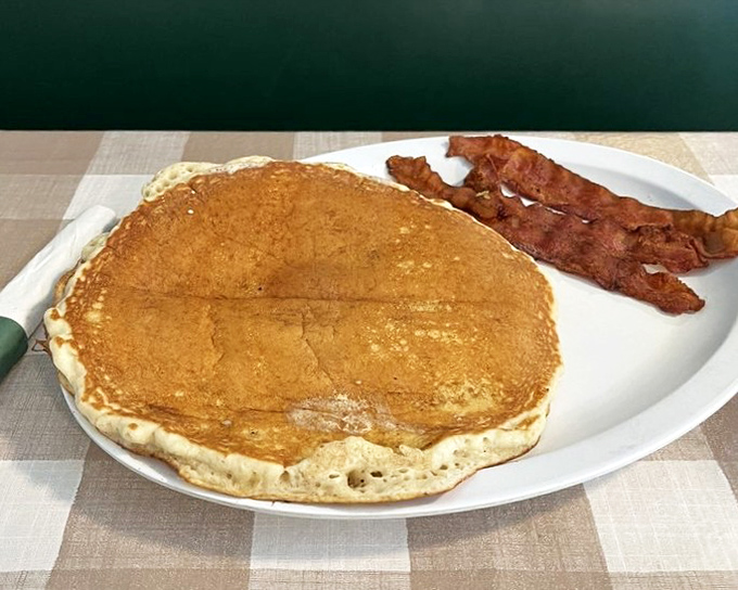 The pancake that ate Mount Dora, with bacon standing guard. Maple syrup not pictured but absolutely necessary for the full experience.