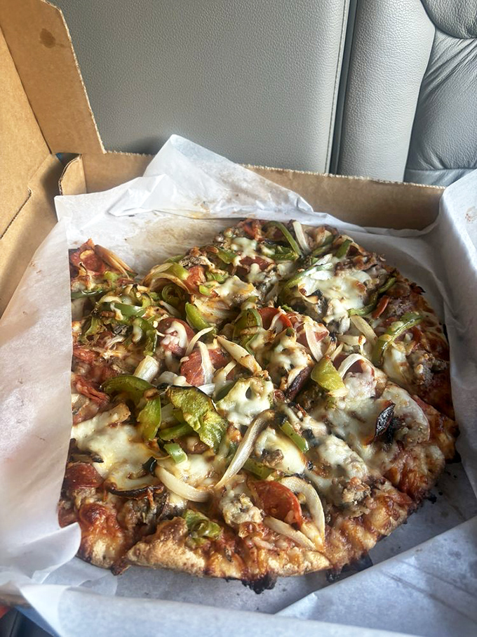 Pizza perfection in a box&mdash;where green peppers and onions dance across a landscape of melted cheese, proving that simple ingredients handled with care create magic.