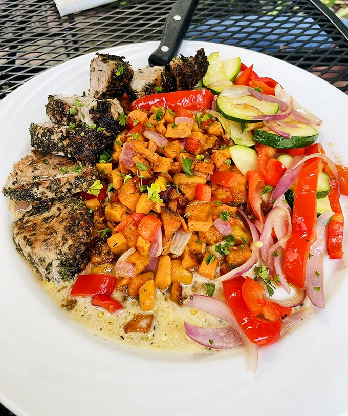 Herb-crusted pork tenderloin surrounded by a colorful medley of vegetables&mdash;proof that eating your veggies can be a revelation.