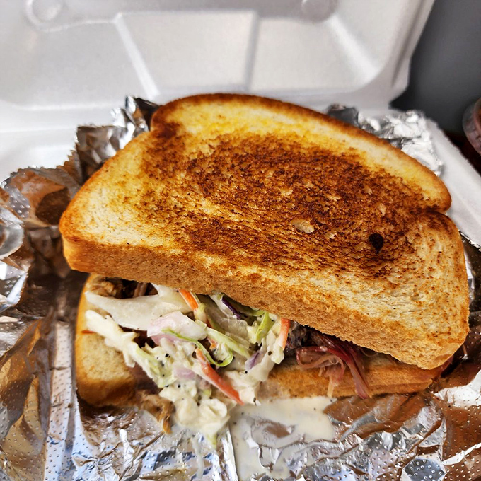 The sandwich that launched a thousand road trips. Golden toast embracing smoky meat and creamy slaw—a harmony of textures that sings.