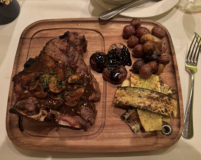 A steak served on wood with mushrooms and vegetables&mdash;because sometimes your meat deserves its own stage and supporting cast.