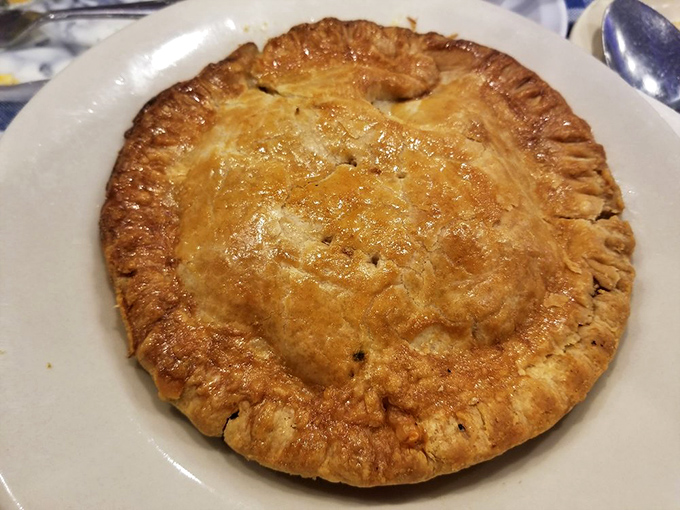 Pot pie arrives like a golden dome of happiness, hiding tender secrets beneath its flaky crust.