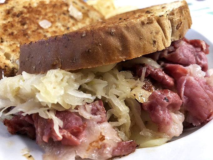The Reuben arrives as a towering testament to the art of sandwich construction, promising corned beef bliss.