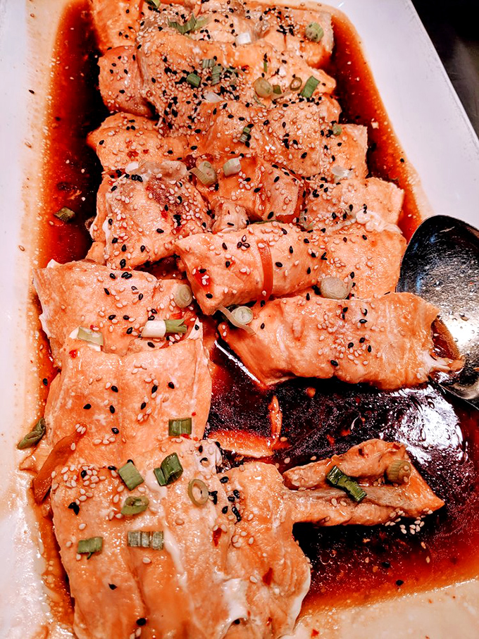 Salmon bathing in savory sauce with a sprinkle of sesame seeds. The kind of dish that makes you forget you're at a buffet.