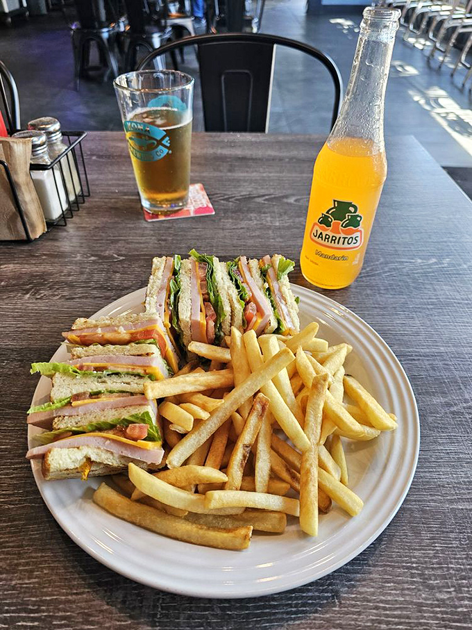 The club sandwich: invented by someone who couldn't decide what they wanted for lunch and accidentally created perfection. Served with a side of golden fries.