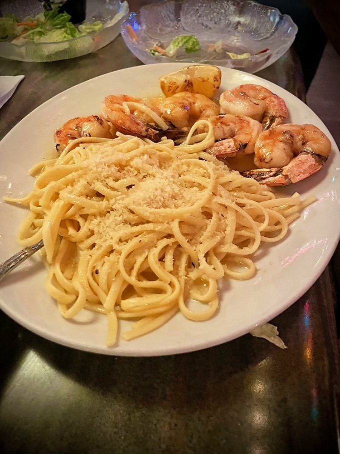 Shrimp scampi swimming in butter and garlic, served over pasta that knows its job perfectly.