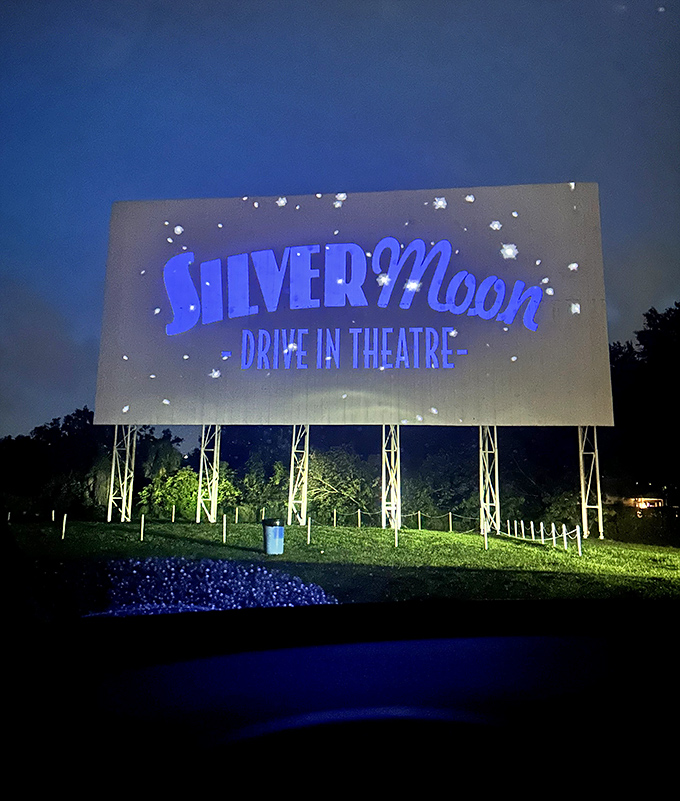 The Silver Moon logo illuminates the night sky, a blue beacon calling movie lovers to gather beneath its glow.