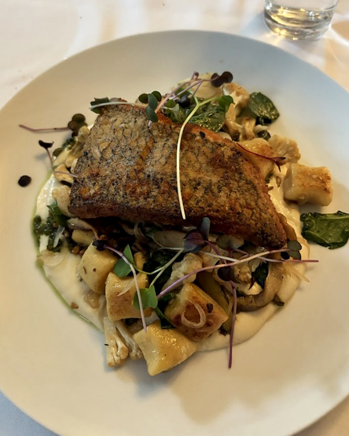 This sea bass wears its perfectly crisped skin like designer fashion, while the seasonal vegetables beneath create a runway-worthy foundation.