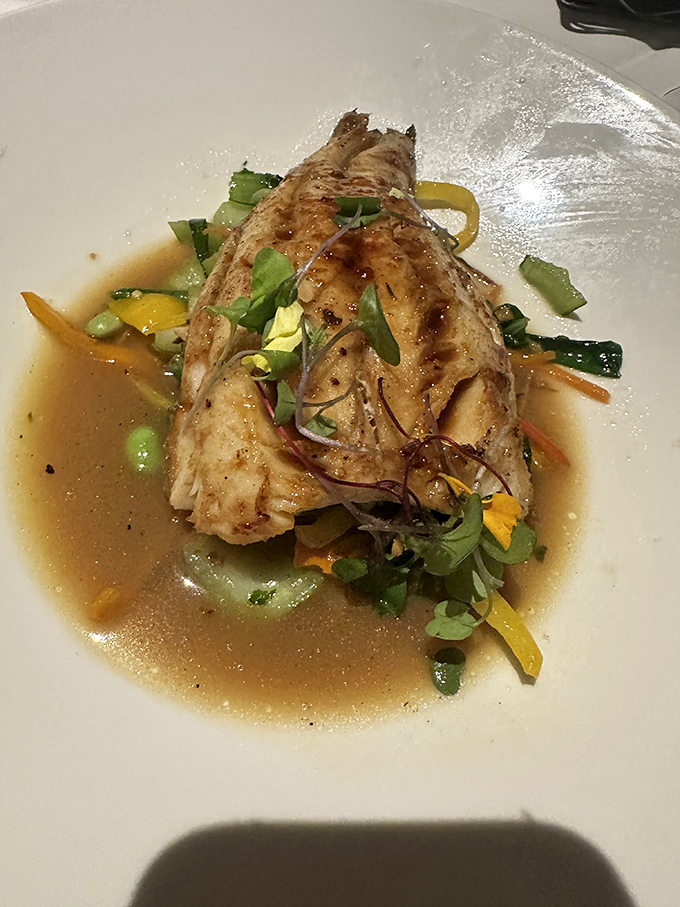 This sea bass floats atop a garden of vegetables like a delicious island nation declaring independence from boring meals everywhere.