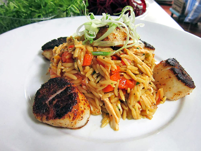 Perfectly seared scallops surrounding a colorful orzo medley&mdash;like tasty sentinels guarding a treasure of pasta and vegetables.