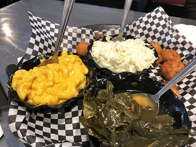 The holy trinity of Southern sides served in checkered baskets. Mac and cheese, potato salad, and collard greens &ndash; a supporting cast that steals the show.