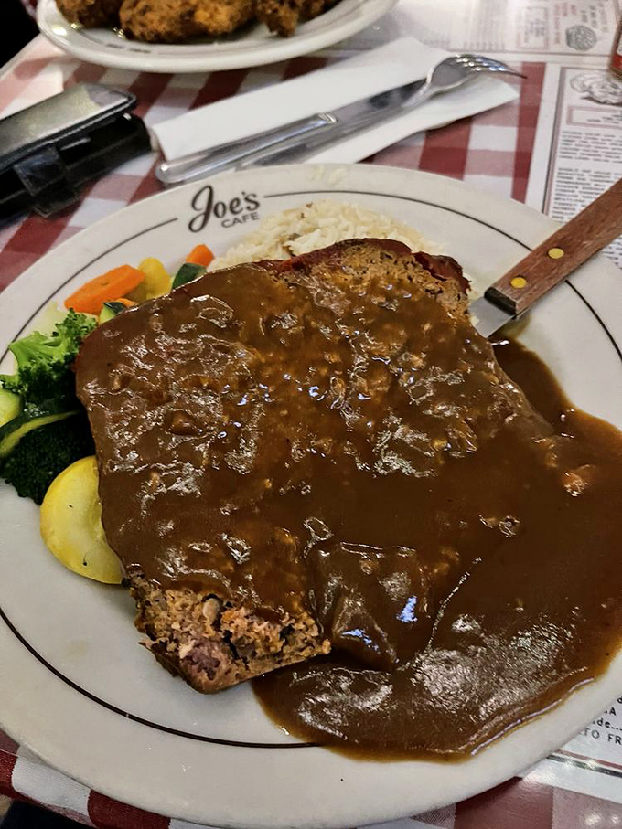 Meatloaf swimming in gravy like it's 1955 and everything's right with the world. Comfort food that hugs you from the inside.