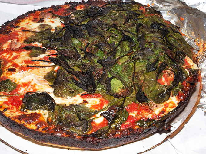 Spinach on pizza usually disappoints, but here it's transformed into charred, crispy-edged flavor bombs atop that legendary crust.
