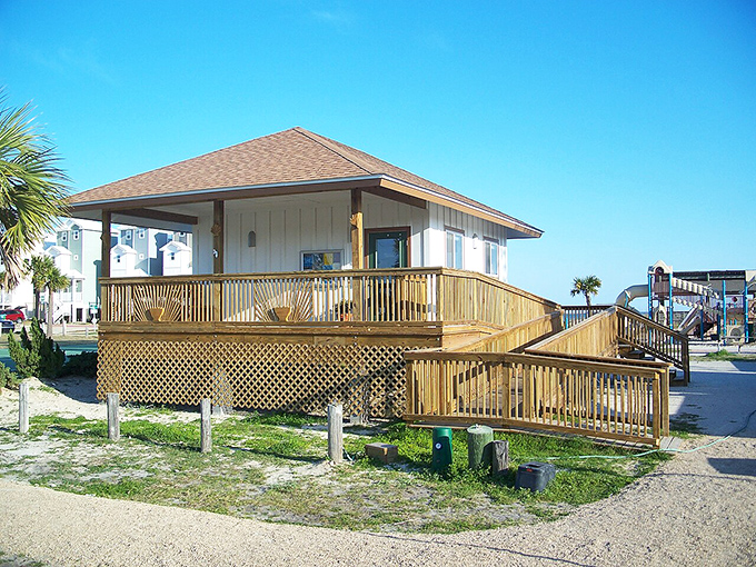 This charming wooden deck offers front-row seats to beach life, proving sometimes the simplest structures create the most lasting memories.