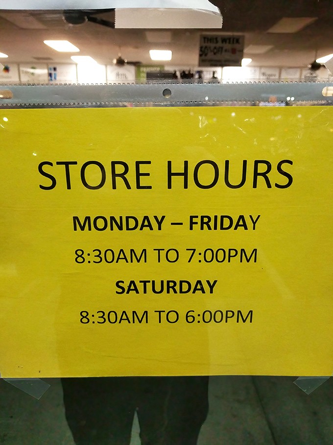 The yellow store hours sign&mdash;memorize these times like sacred text if you want first dibs on fresh merchandise.