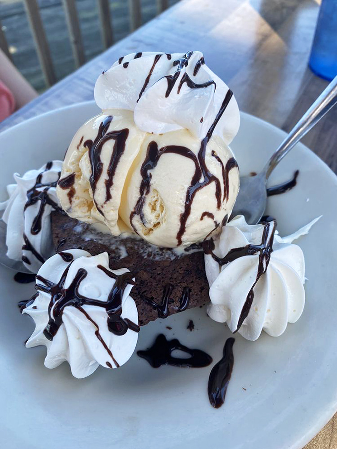 This brownie sundae isn't just dessert, it's an architectural achievement of chocolate, ice cream, and whipped cream that demands to be photographed.
