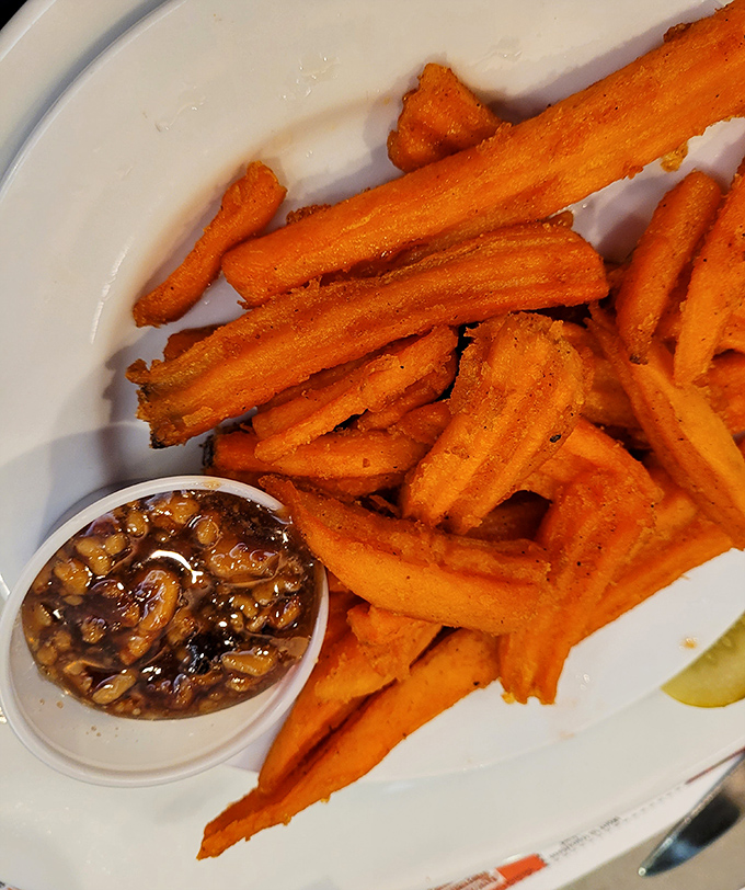 Sweet potato fries with the perfect crisp-to-soft ratio, accompanied by a dipping sauce that makes ketchup seem like a distant, forgotten relative.
