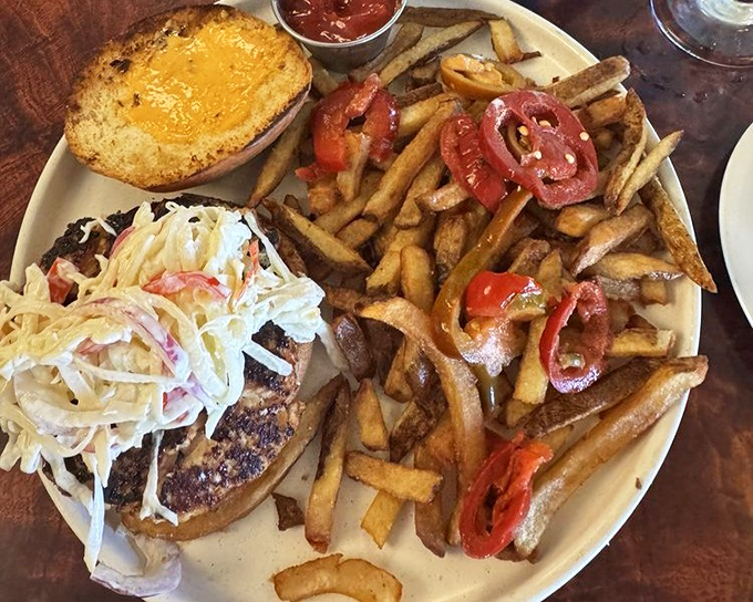 This towering burger with crispy fries proves that comfort food can reach artistic heights of deliciousness.