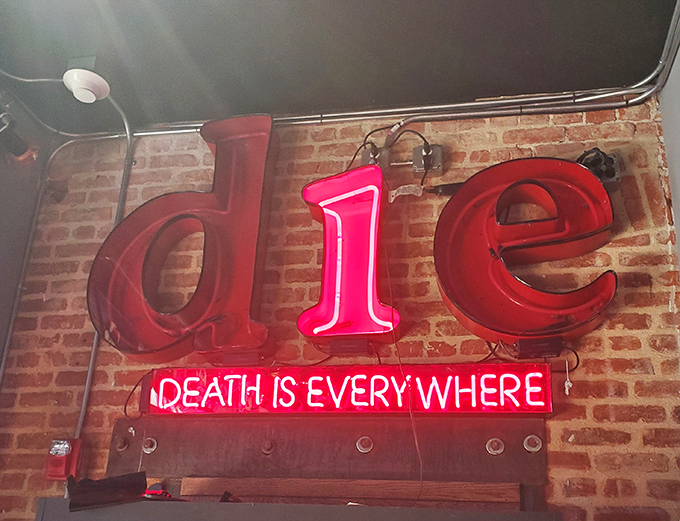 "Death is Everywhere" proclaims the neon sign, bringing a touch of Vegas flair to life's ultimate destination.