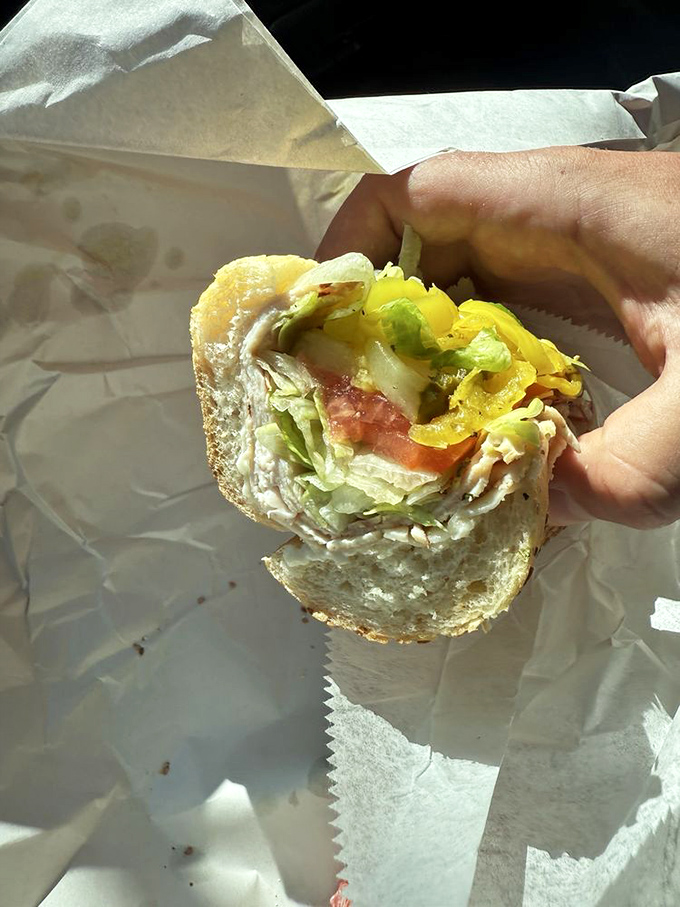 A half-eaten hoagie reveals its secrets&mdash;layers of meat, cheese, and veggies in perfect proportion. Someone couldn't wait to finish before taking a photo.