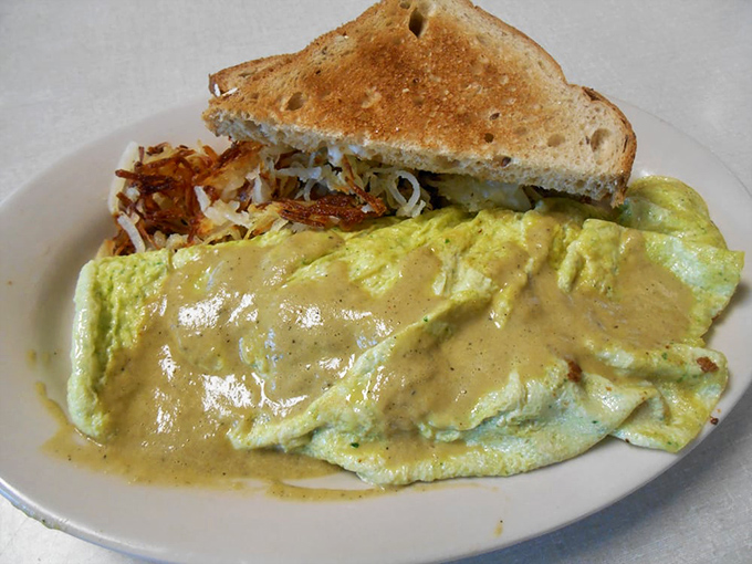 This isn't just an omelet&mdash;it's a golden envelope delivering a love letter of ingredients beneath a blanket of cheese sauce that means business.