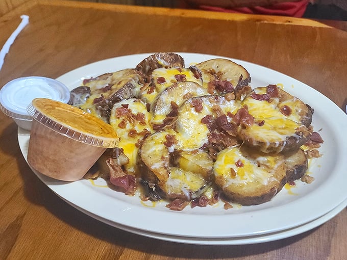 Potato wedges living their best life under a blanket of melted cheese and bacon&mdash;proof that sometimes the side dish steals the spotlight.