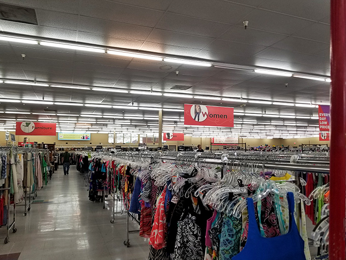 An ocean of clothing racks stretches to the horizon, with comfy couches strategically placed for weary shopping companions.
