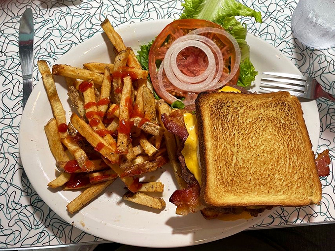 The humble grilled cheese elevated to art form. Perfectly golden bread, melty cheese, and those fries with ketchup stripes? Pure diner poetry.