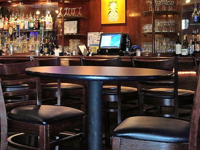 The bar area exudes warm sophistication with rich wood tones and a pineapple motif. It's the perfect perch for happy hour or pre-dinner cocktails.