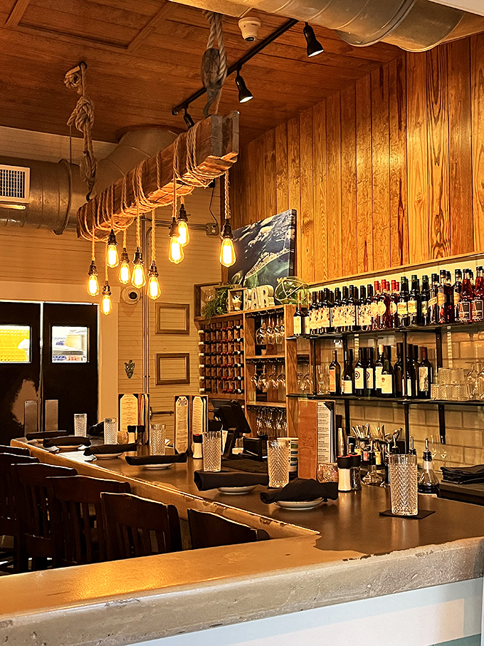 The bar doesn't just serve drinks—it serves atmosphere. Those Edison bulbs dangling from nautical rope weren't just designed; they were curated.